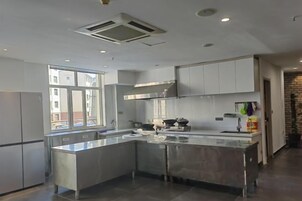 Cozinha moderna com uma ilha grande, eletrodomésticos de aço inoxidável e vista para a cidade.