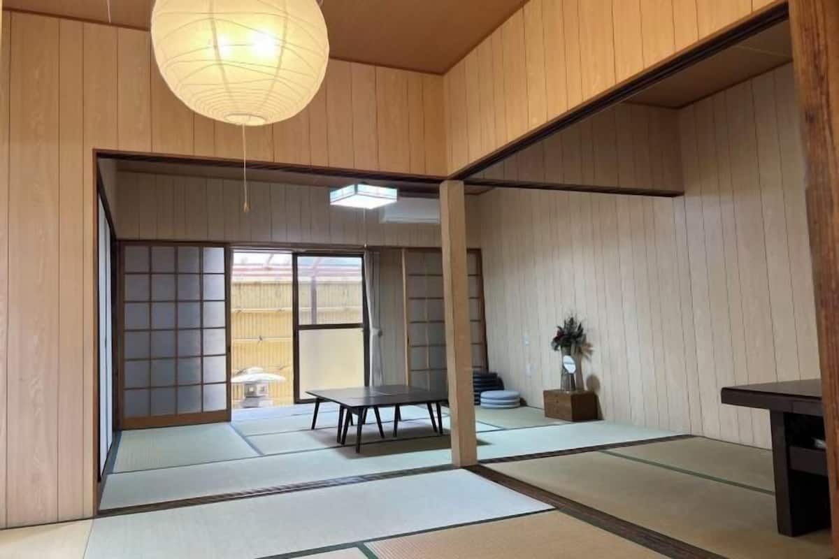 Um quarto japonês tradicional com tatames, uma mesa baixa e portas deslizantes.