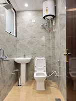 Uma casa de banho moderna com sanita, lavatório e chuveiro.