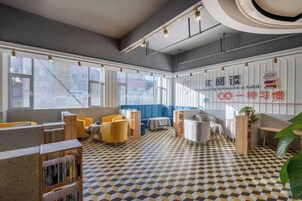 Decoração moderna com chão quadriculado, áreas de estar e parede com texto.