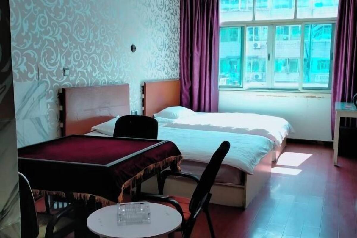 Quarto de hotel com uma cama, uma mesa e uma cadeira.
