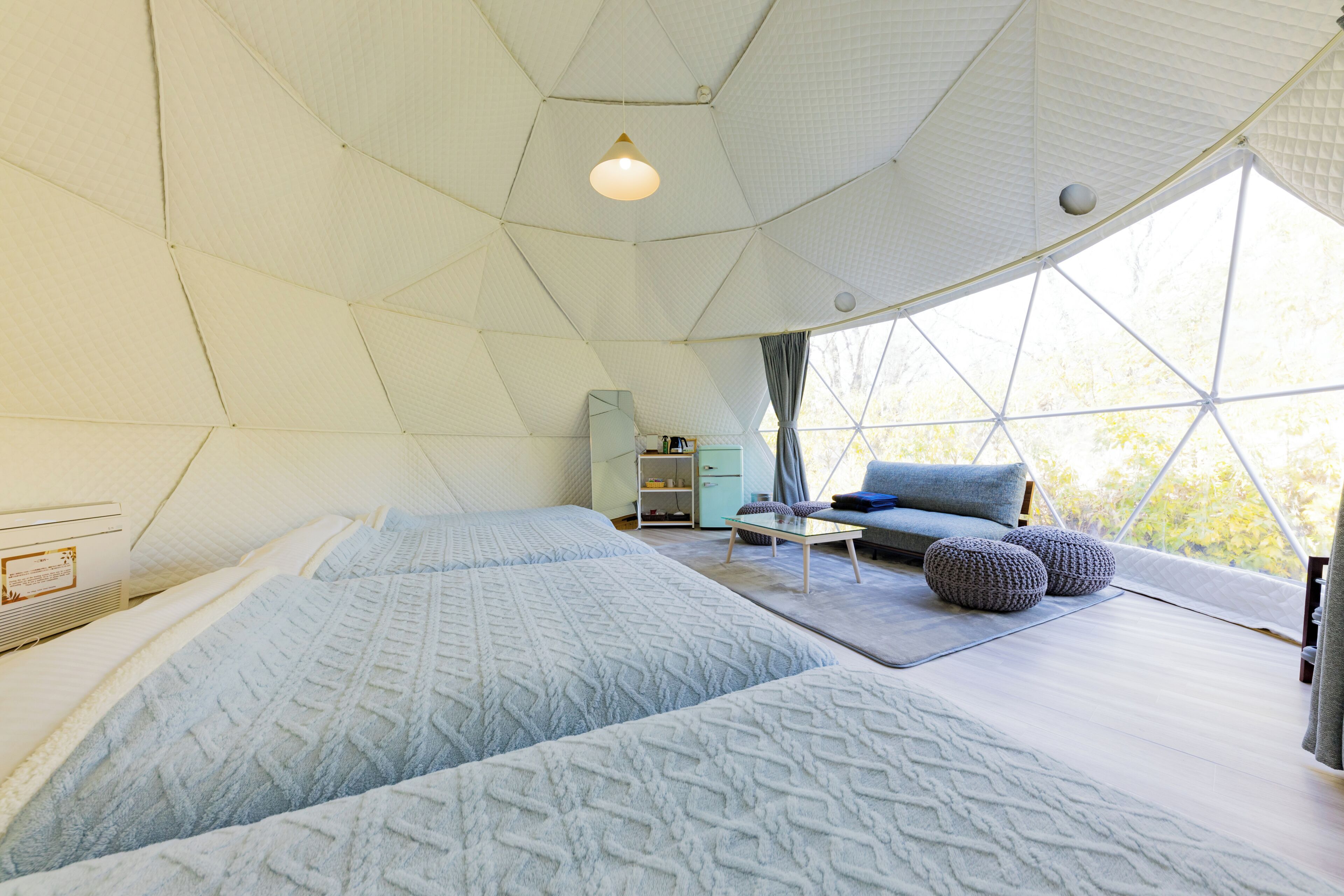 Um quarto espaçoso com uma cama grande, uma mesa pequena e um sofá.