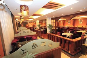 Interior de restaurante com cabines, mesas e balcão.