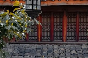 Um edifício tradicional com telhado de azulejos e uma janela com padrão em treliça.