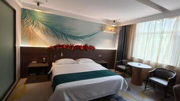 Quarto de hotel com uma cama, uma mesinha, duas cadeiras, parede decorativa e janela com cortinas.