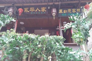 Um edifício tradicional com fachada de madeira, sinalização indicando um restaurante e entrada coberta.
