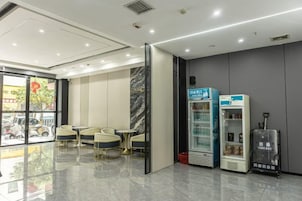 Interior moderno com assentos, máquinas de venda automática e porta de vidro que dá para o exterior.