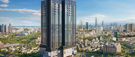 Um edifício alto com design moderno, apresentando uma entrada notável e vários andares.