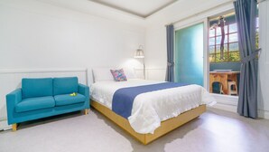 Quarto com cama, um sofá azul, luminária e janela com cortinas.