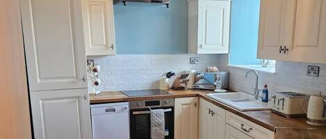 Um frigorífico, um micro-ondas, um forno, uma placa de cozinha