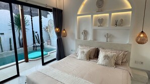 Quarto moderno com cama grande, banco embutido, vista para piscina e luminária circular no teto.