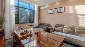Uma sala de estar moderna com uma mesa de centro de madeira, sofás de couro e uma janela grande que traz luz natural.