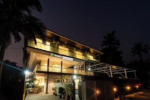 Um hotel com design moderno, com uma varanda em destaque e área externa coberta.