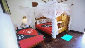 Quarto com duas camas, cada uma com dossel e colchão vermelho.