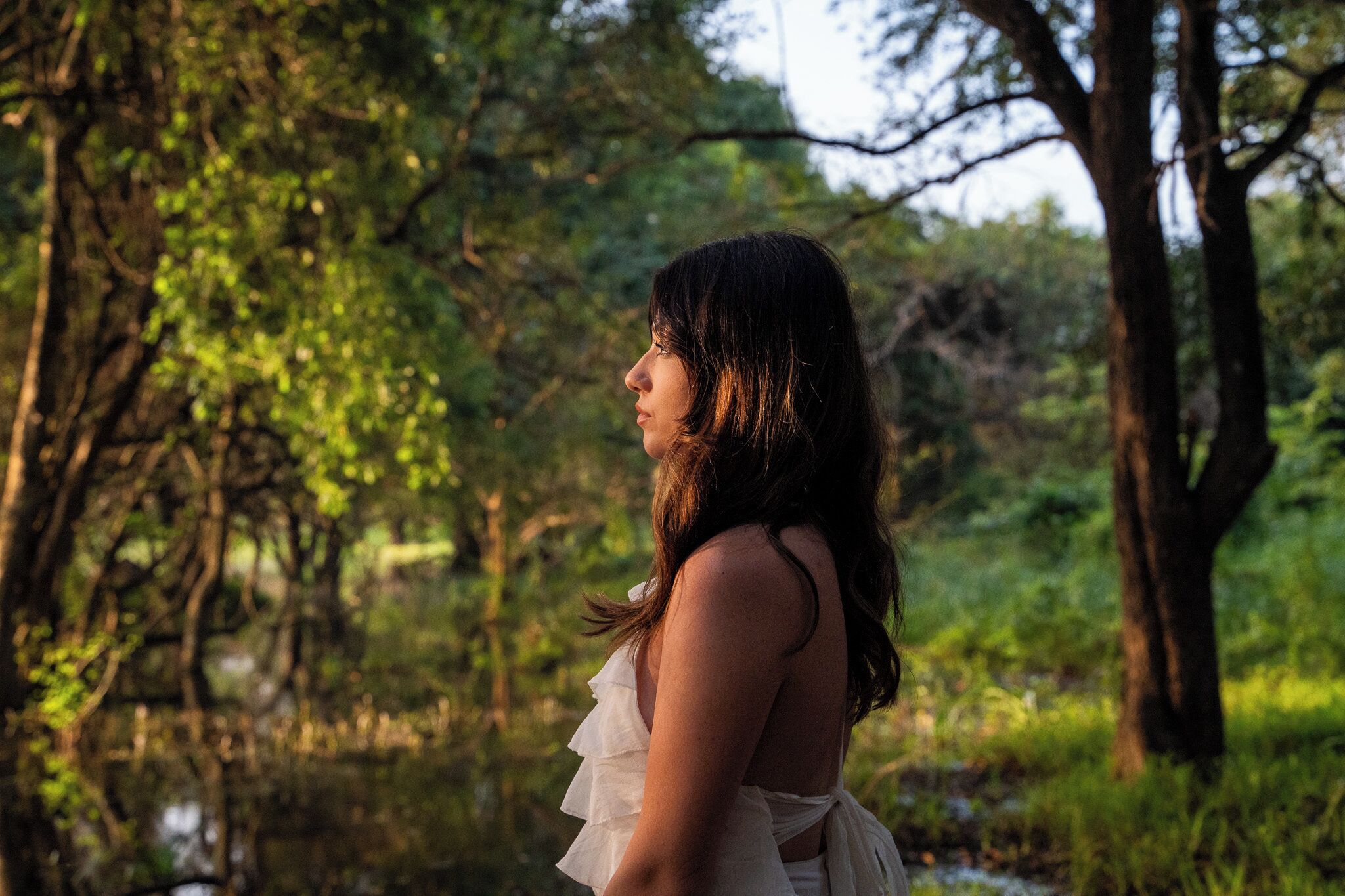 Uma pessoa em um ambiente natural, com árvores e vegetação.