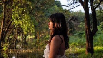 Uma pessoa em um ambiente natural, com árvores e vegetação.