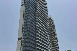 Um edifício alto e moderno, com fachada uniforme e várias janelas.