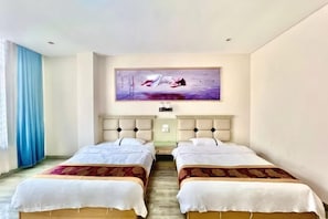 Quarto de hotel com duas camas, um quadro grande na parede e uma janela com cortinas azuis.