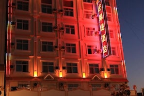 Um edifício de hotel com vários andares e uma placa chamativa.