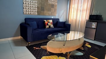 Suíte estúdio superior, vista para o pátio | Área de estar | TV de tela plana 42 polegadas com canais a cabo
