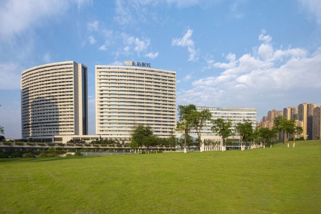 Um hotel com fachada curva, vários andares e telhado plano.