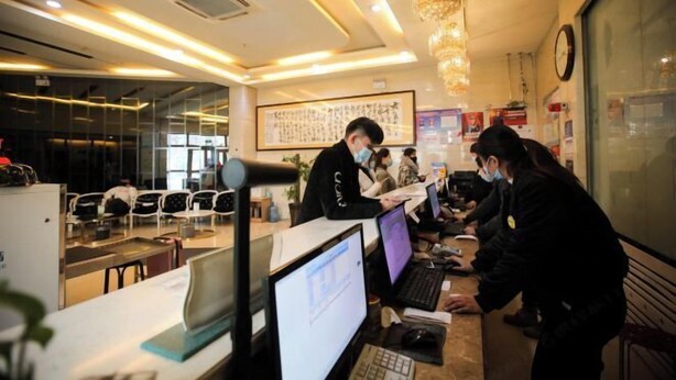 Um espaço de escritório moderno com mesas, computadores e cadeiras.