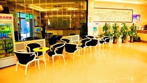 Um café moderno com cadeiras pretas e brancas, um painel de vidro e uma máquina de venda automática.