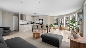Um espaço de estar moderno com cozinha, área de refeições e zona de estar.
