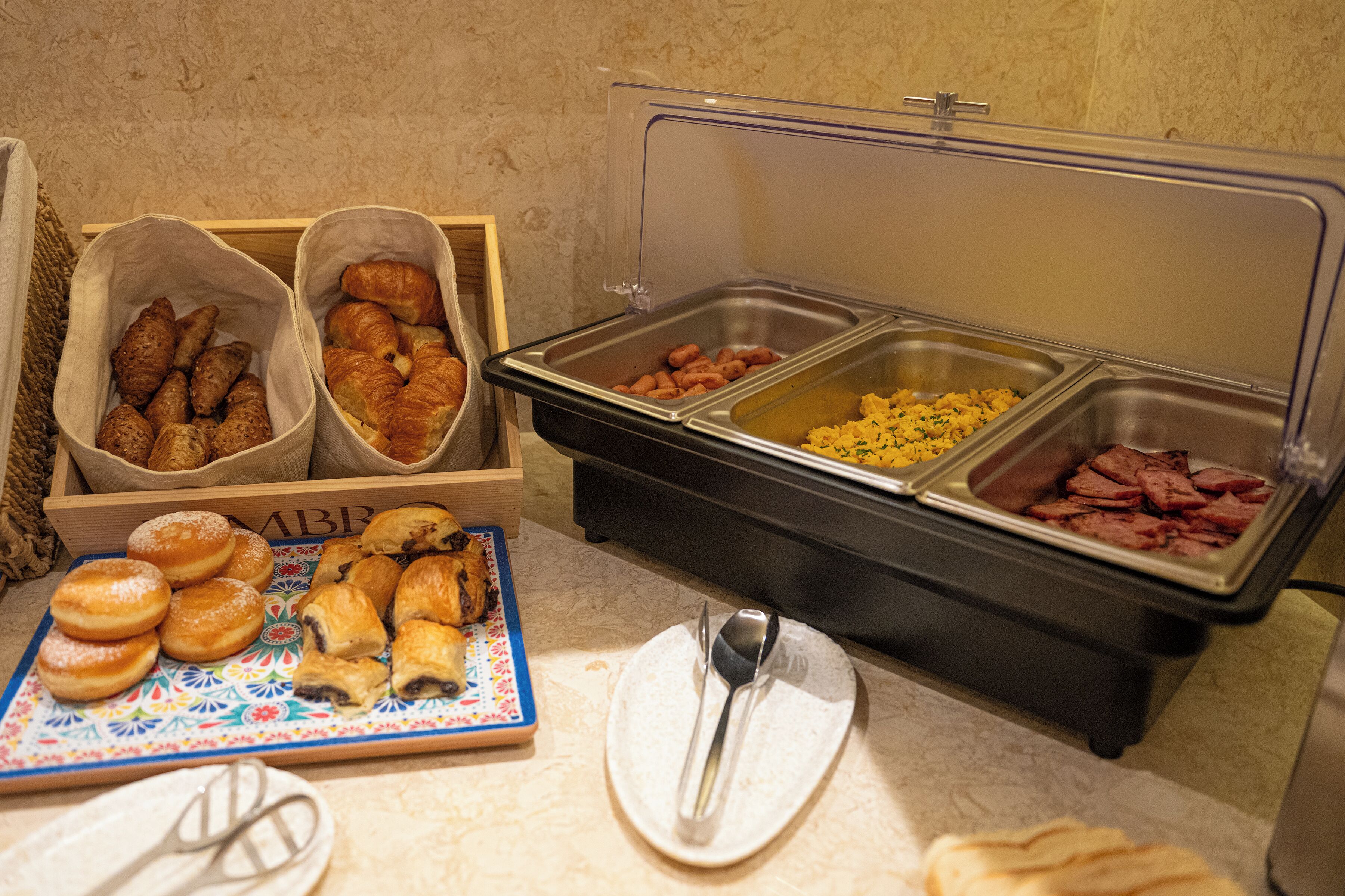 Buffet com diversos alimentos, incluindo doces, carnes e ovos.
