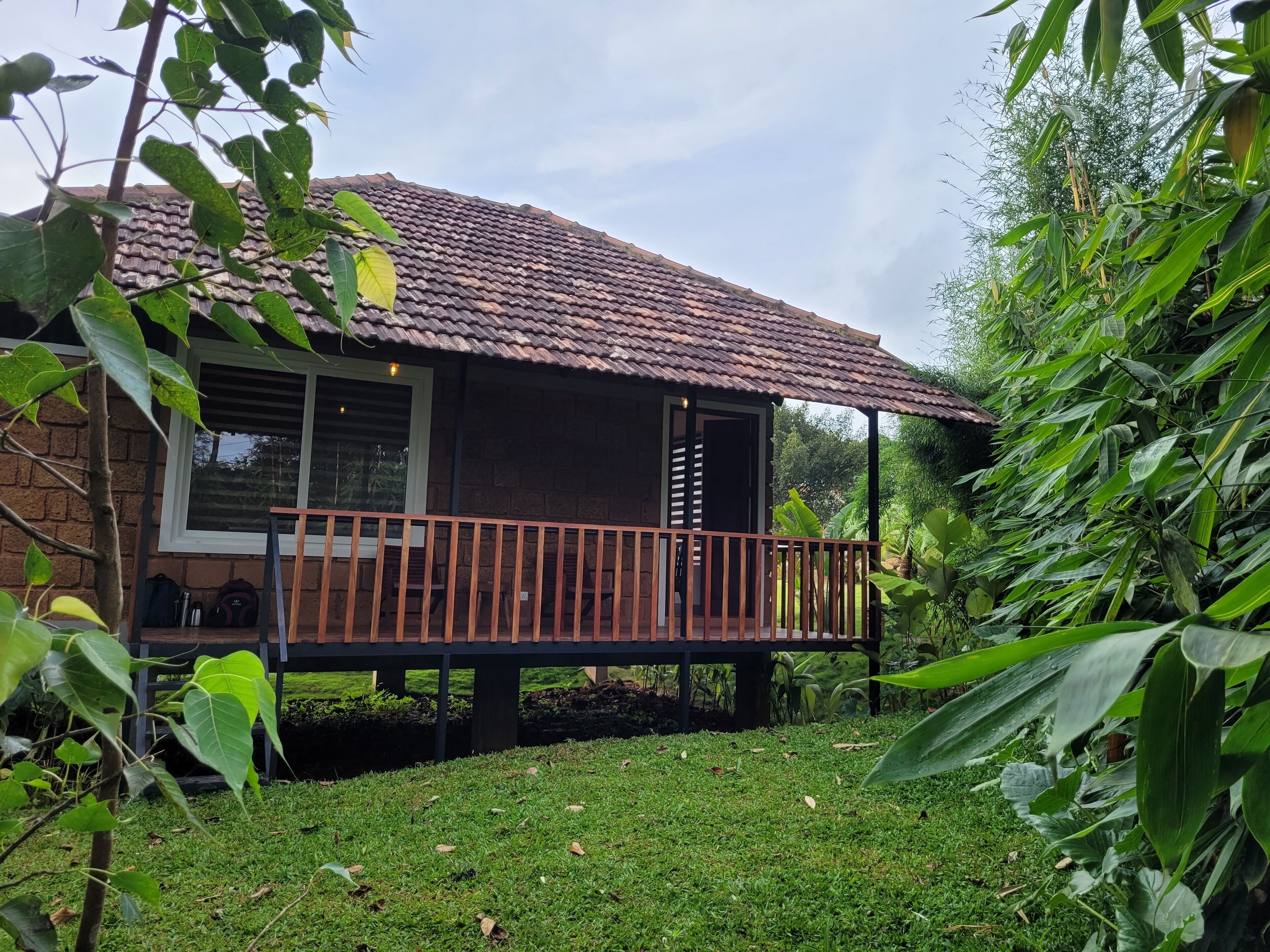 Uma casa pequena e rústica, com telhado de telhas e varanda de madeira.
