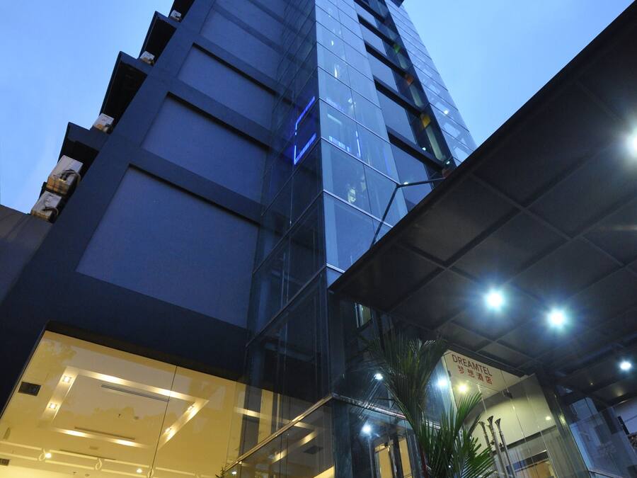 Um edifício moderno com fachada de vidro, escadaria visível e uma placa com a inscrição "DREAMTEL".