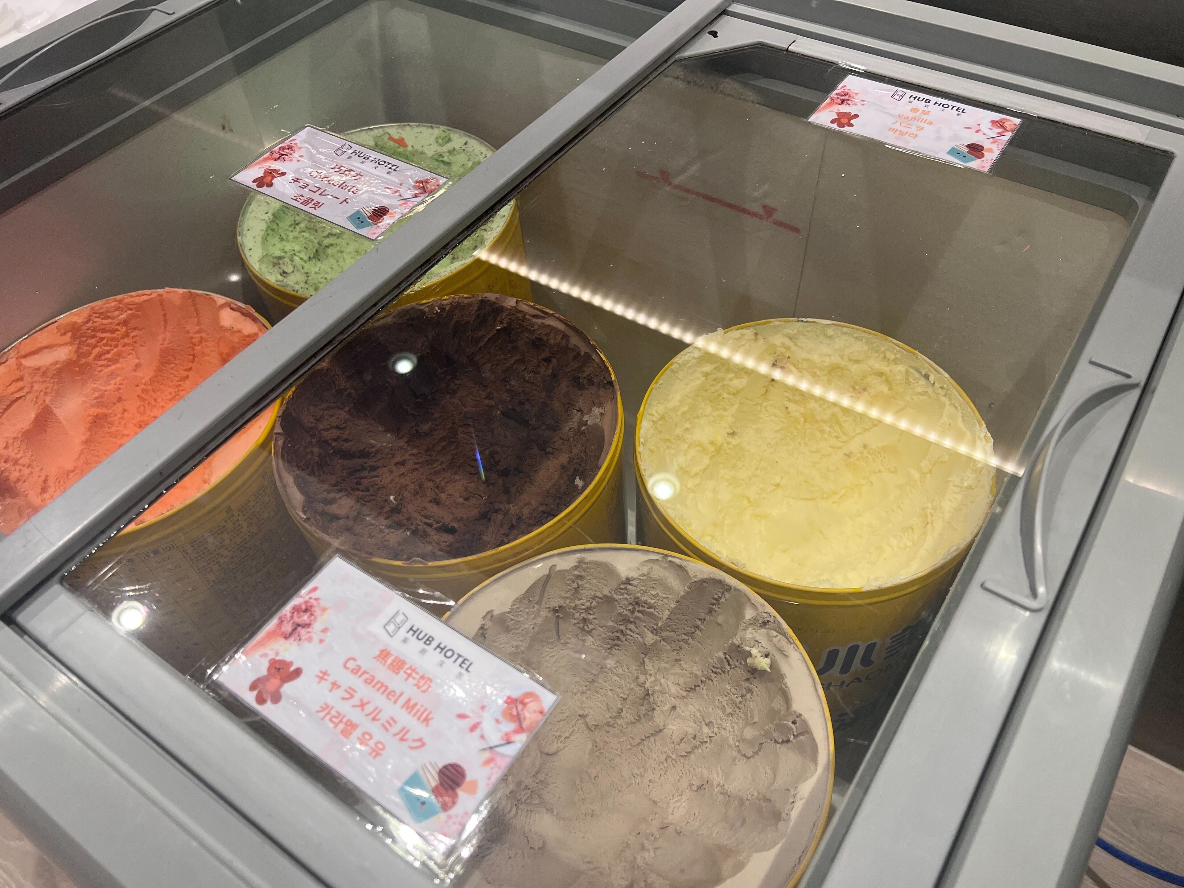 Vitrine com diversos sabores de sorvete identificados em japonês.