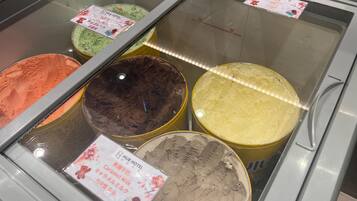 Vitrine com diversos sabores de sorvete identificados em japonês.