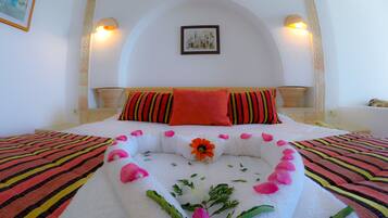 Cama bem arrumada com um arranjo floral e colchas listradas.