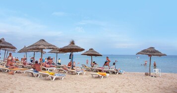 Uma praia privada, espreguiçadeiras, guarda-sóis de praia 