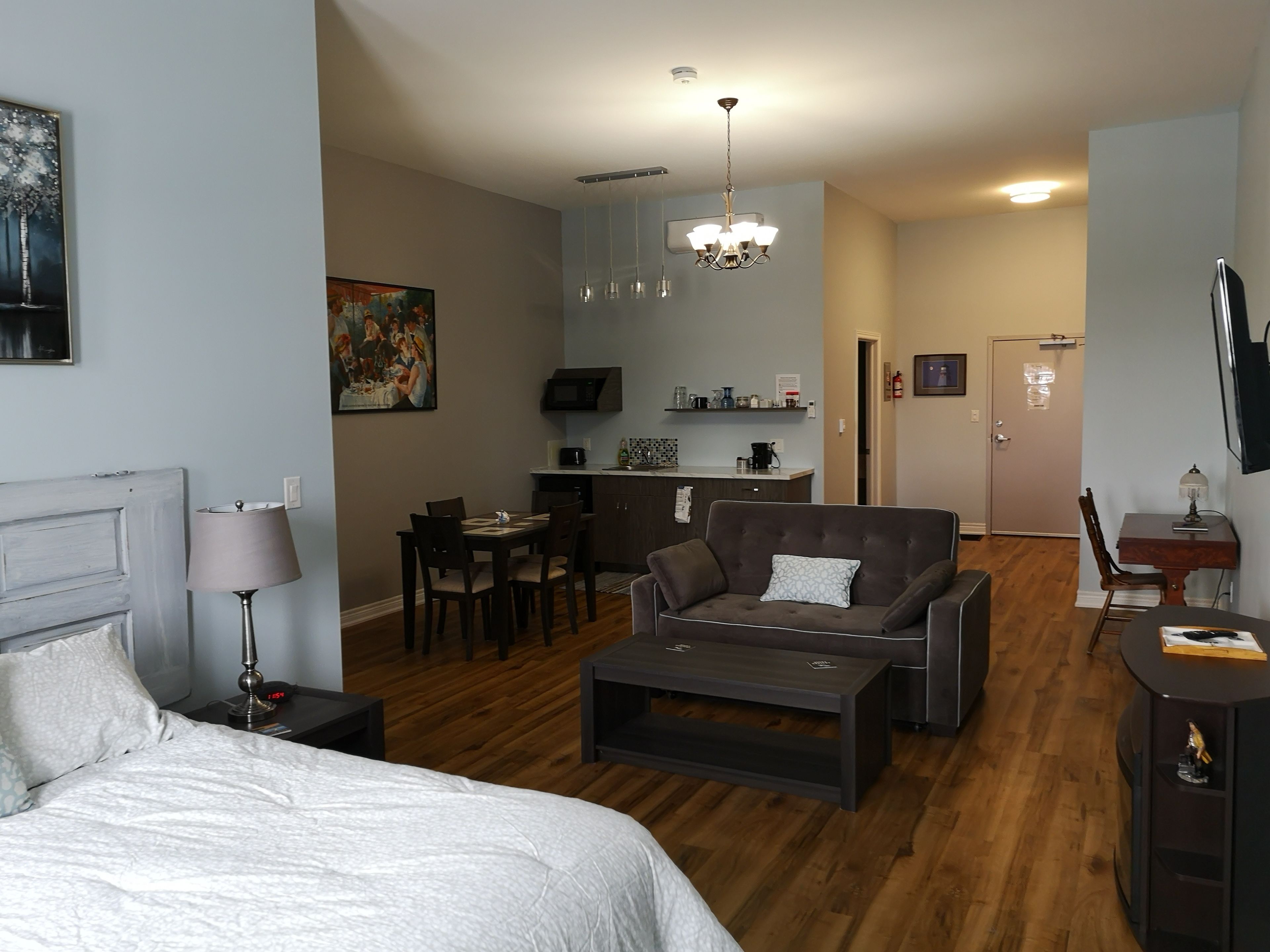 Uma sala de estar moderna com um sofá, mesa de centro e um espaço de jantar com cadeiras e uma mesa.