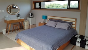 Quarto com cama, escrivaninha, cadeira, espelho, janela e aquecedor.