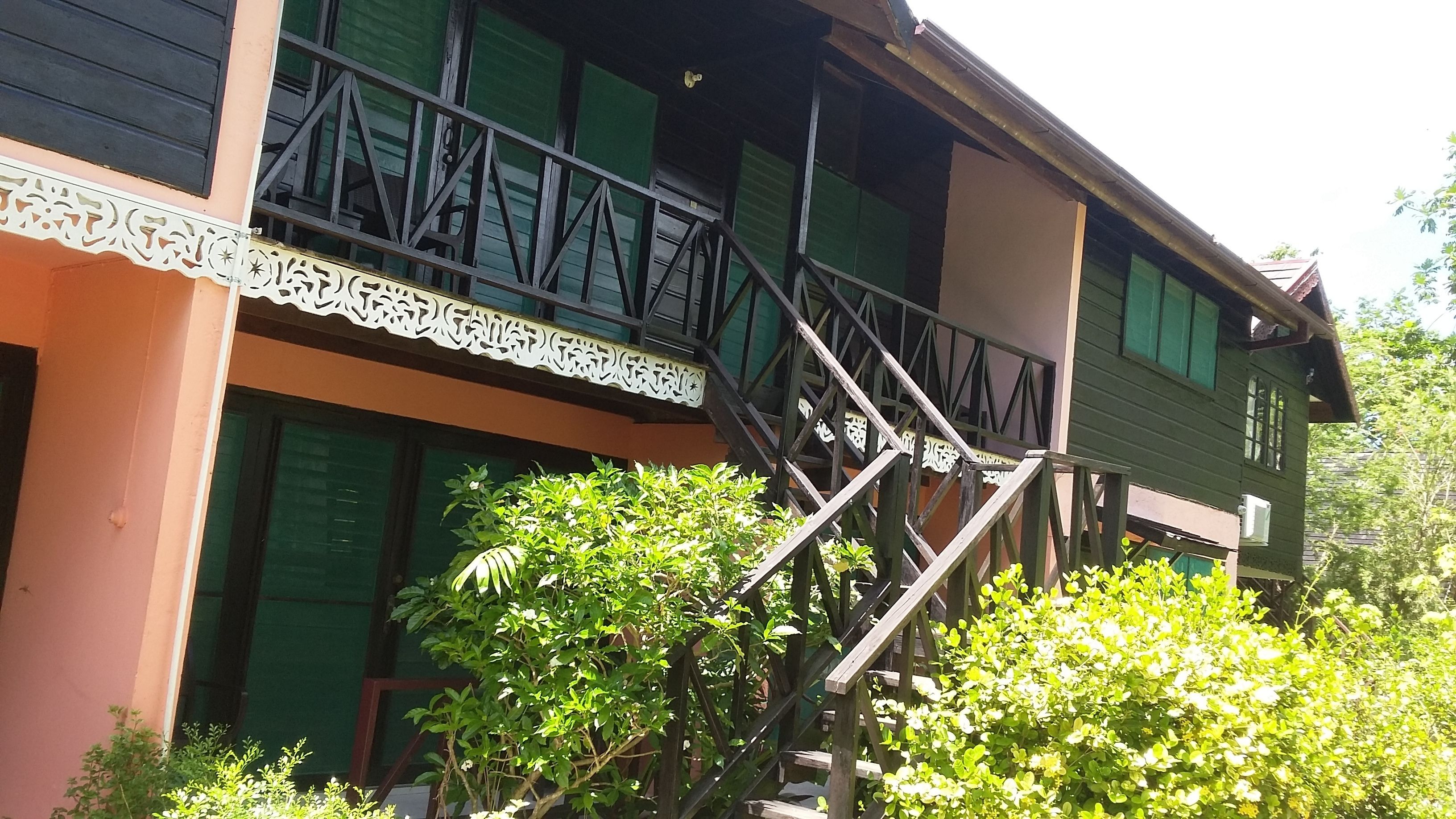 Um edifício de dois andares com varanda e escada.