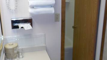 Casa de banho com lavatório, dispensador de toalhas e telefone.