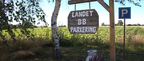Uma placa de madeira com a inscrição 'LANDET BB PARKING' e um símbolo de estacionamento.
