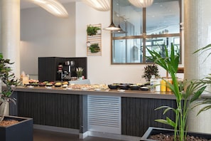 Cozinha moderna com ilha central, eletrodomésticos embutidos e uma grande janela que oferece luz natural.