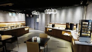 Um restaurante moderno com balcão central, área de estar e iluminação decorativa.
