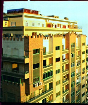 Um hotel com vários andares, varandas e aparelhos de ar condicionado.