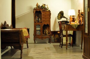 Quarto com um armário de madeira, uma escrivaninha com abajur e uma cadeira.