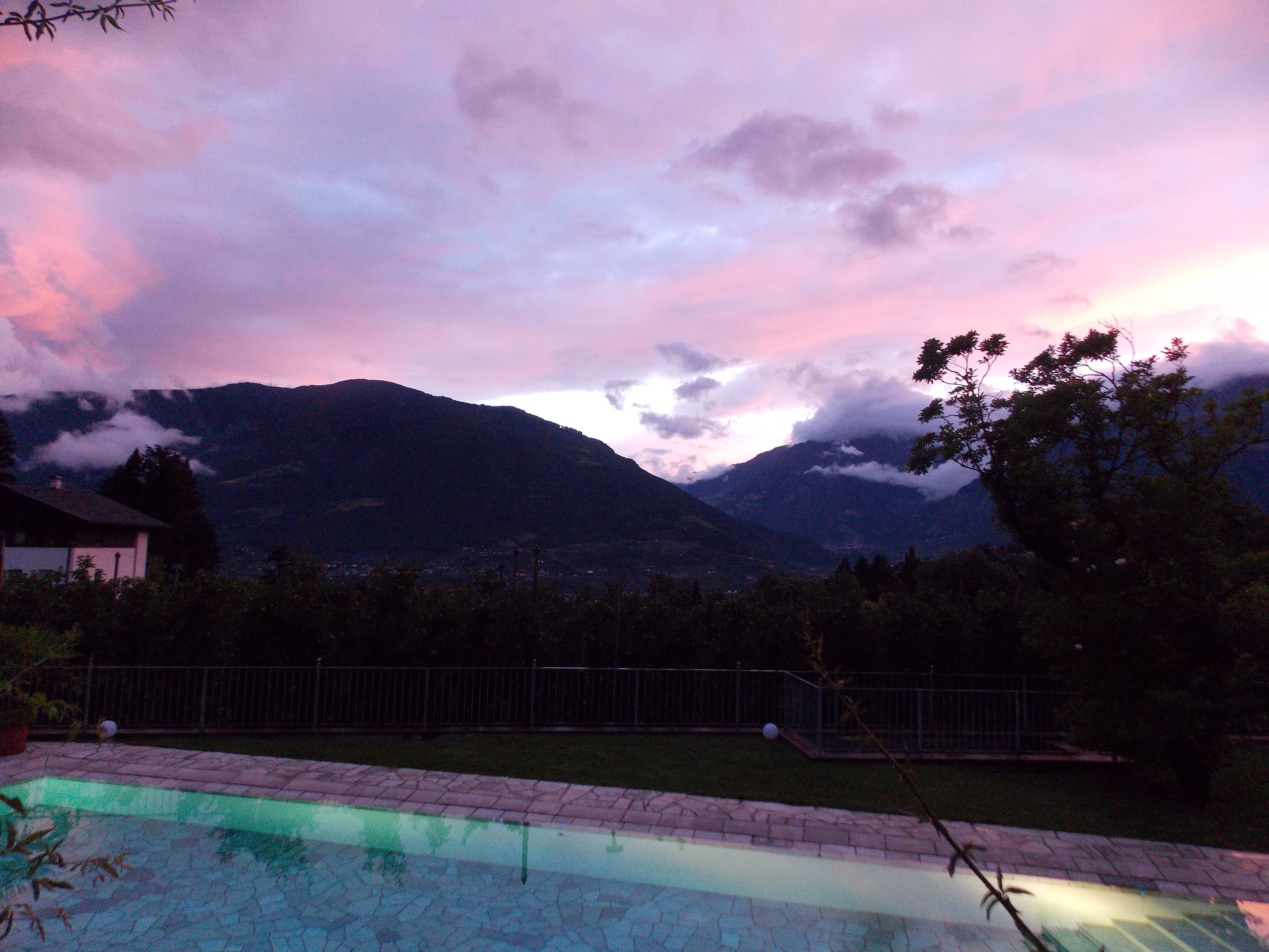 Piscina com vista para montanhas e um céu nublado.