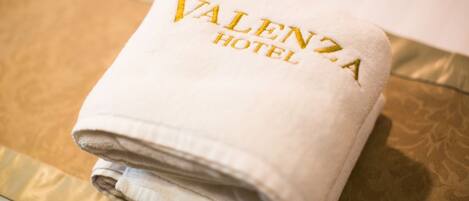Toalha dobrada com o bordado em dourado "Valencia Hotel".