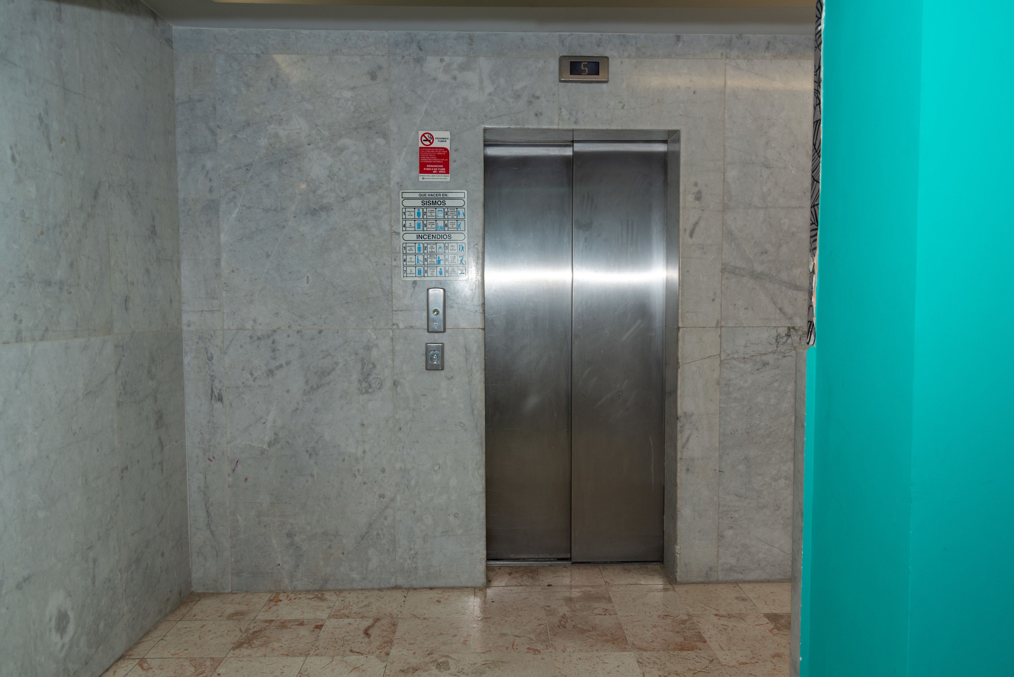 Um elevador com painel de comando e instruções de emergência.