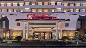 Um hotel com fachada moderna, apresentando uma placa chamativa do Hilton Garden Inn.