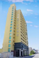 Um edifício alto e amarelo com uma placa que diz "River Hotel" e uma placa indicando classificação cinco estrelas.