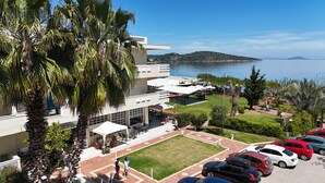 Hotel com área de estar externa, estacionamento e vista para o mar.